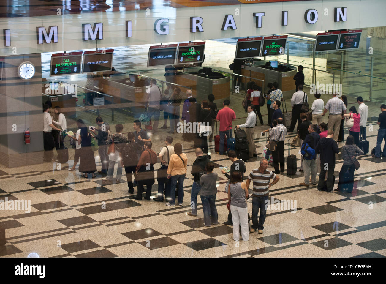 Passengers wait at the immigration counters of Terminal Three at Changi ...