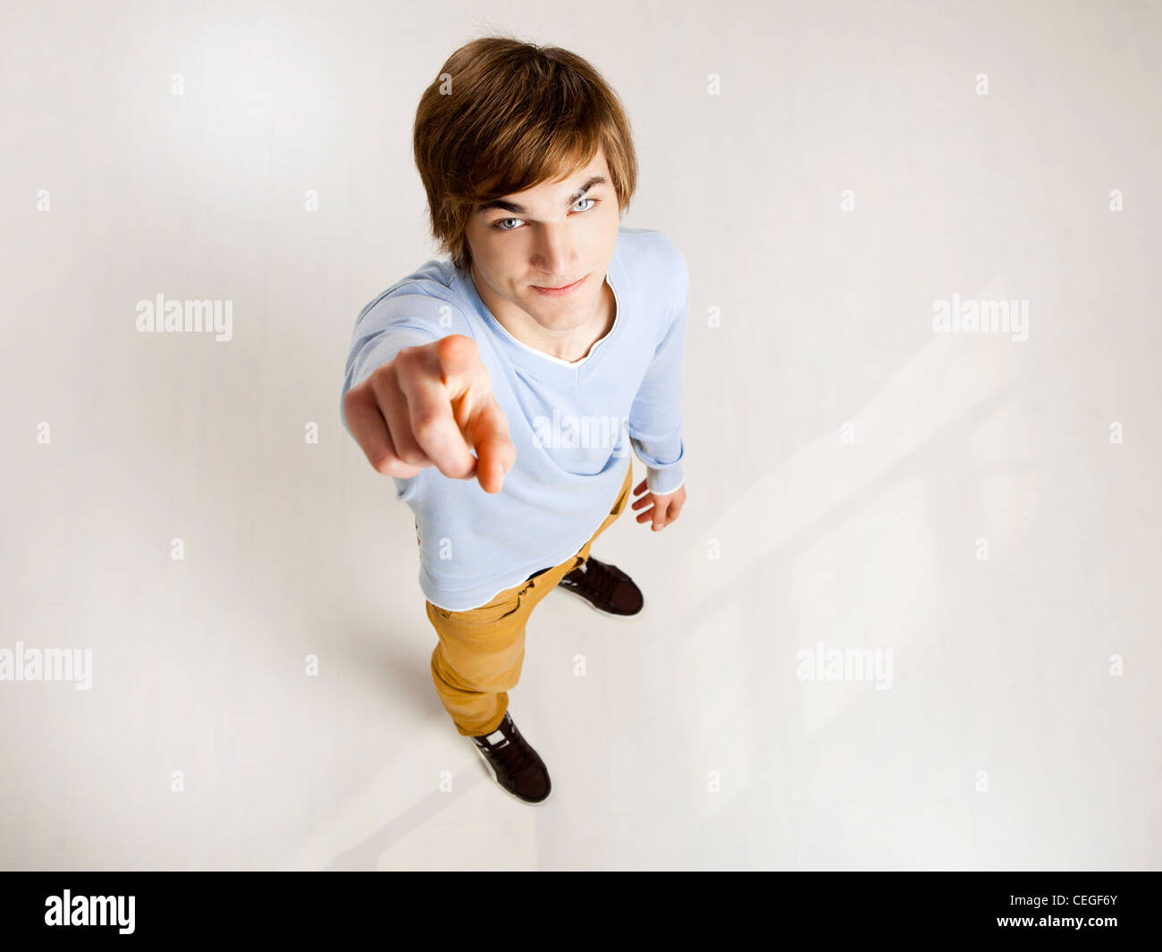 Portrait of a handsome young man looking and pointing to the camera ...