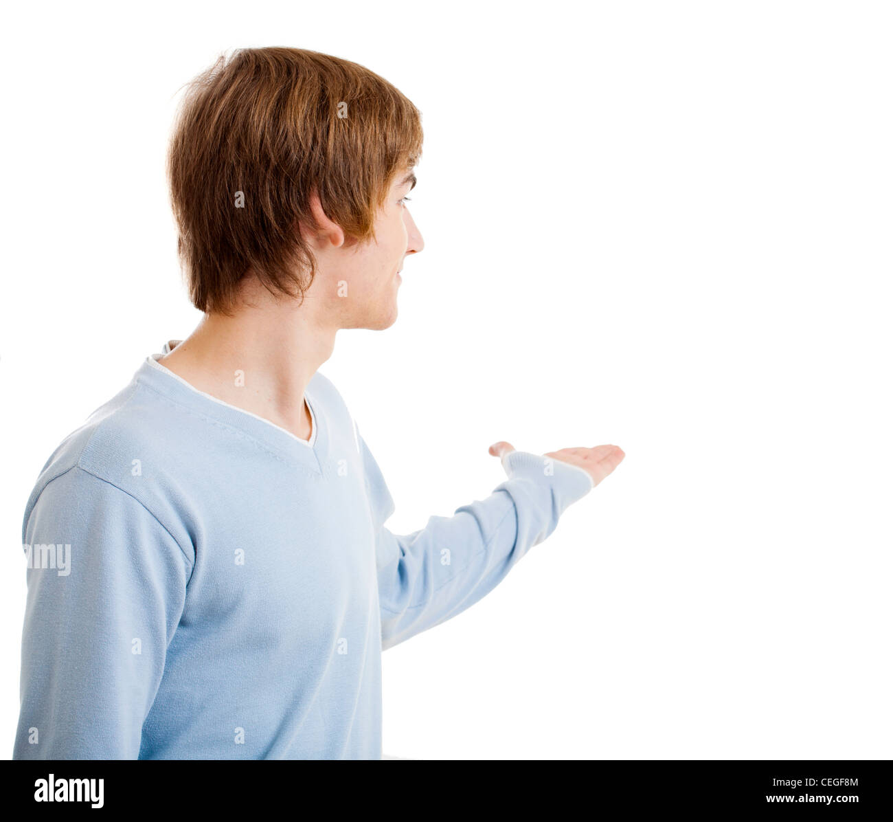 Young man showing something and pointing, isolated on white background ...