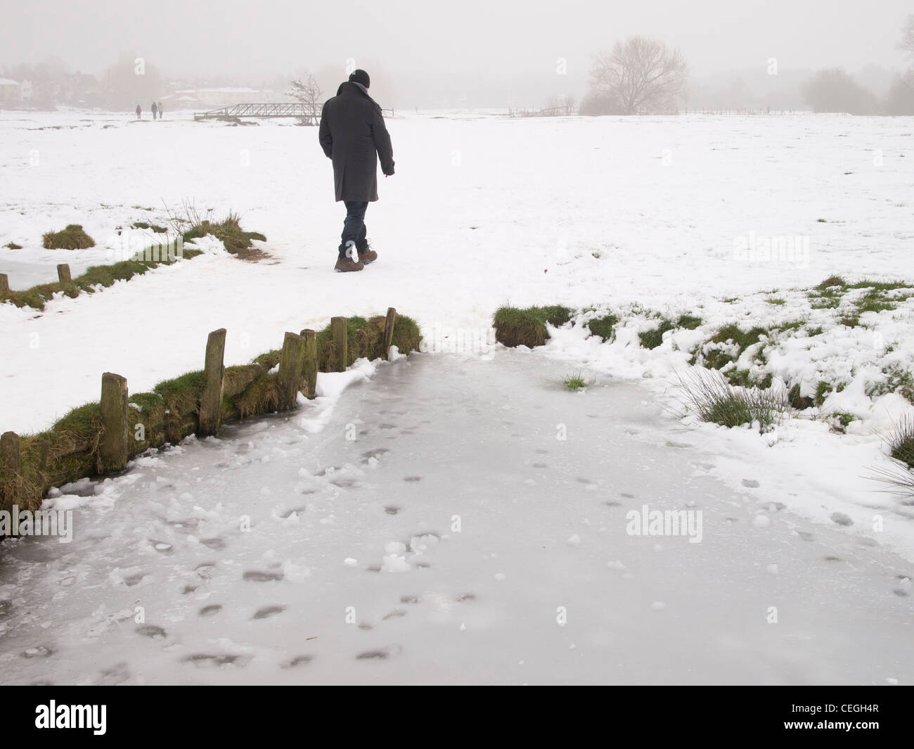 A man walking in snow in a freezing winter landscape Stock Photo - Alamy