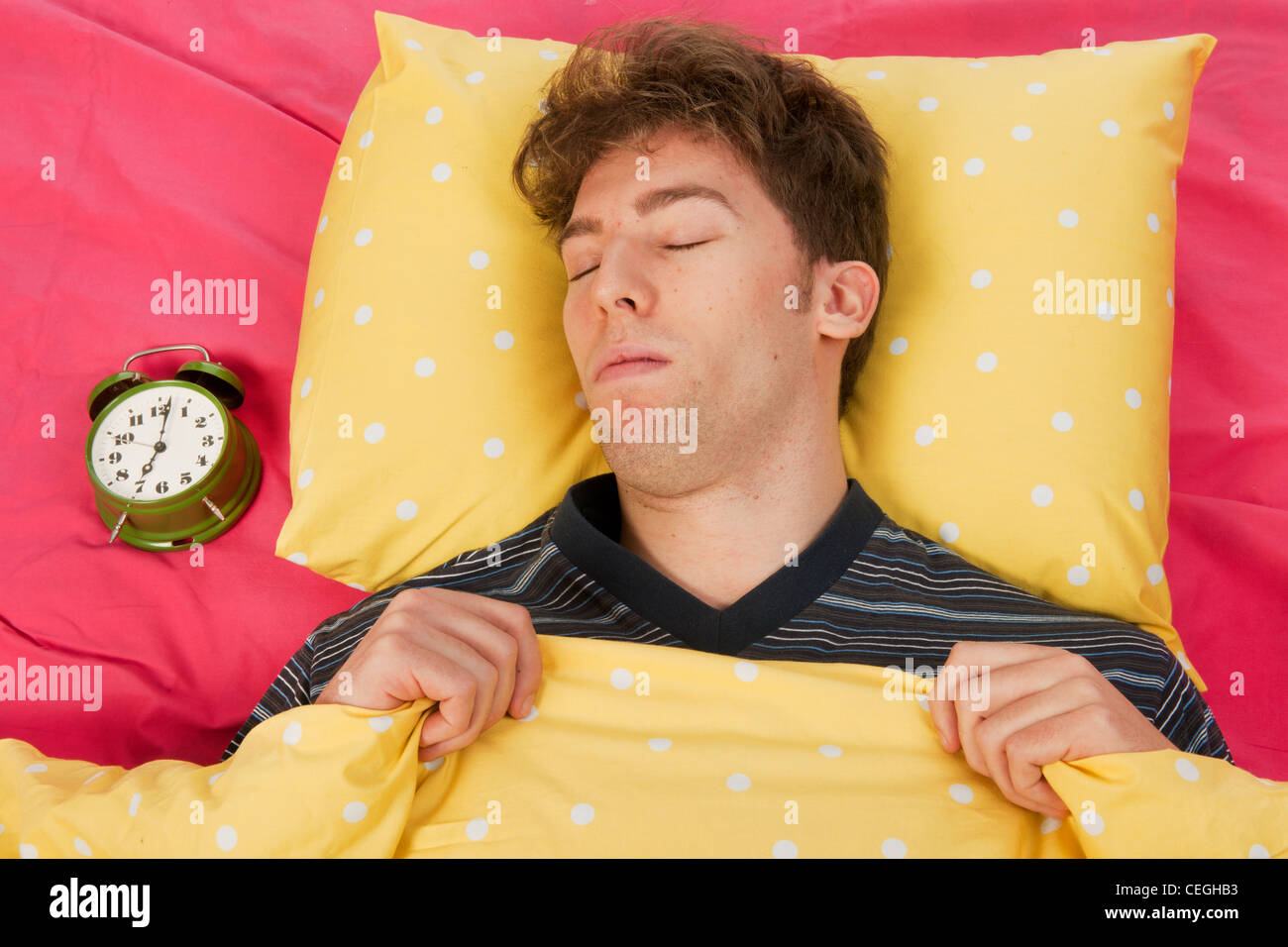 Man sleeping in bed with head on yellow pillow Stock Photo - Alamy