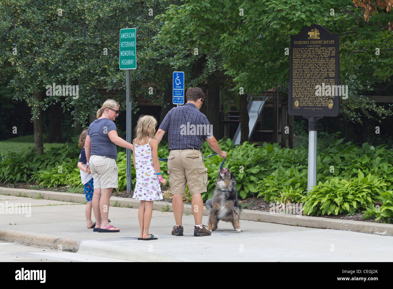 The young American family with two litte children and a dog on the city street on the vacation ...