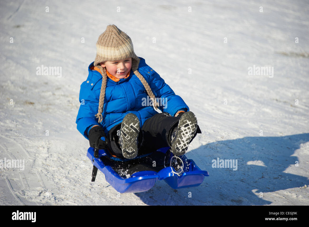 A child little boy sledding downhill winter Stock Photo - Alamy