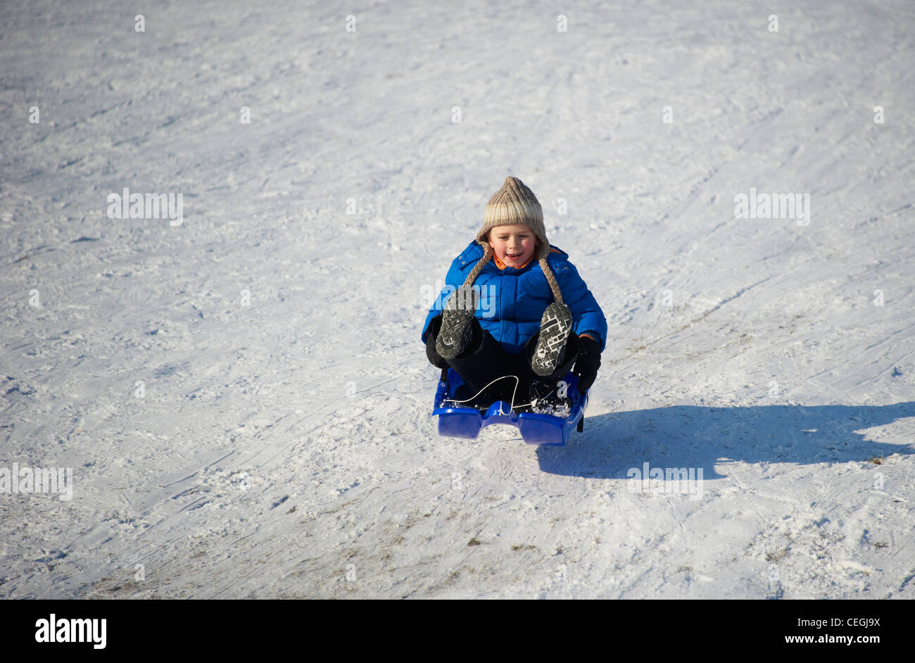 A child little boy sledding downhill winter Stock Photo - Alamy