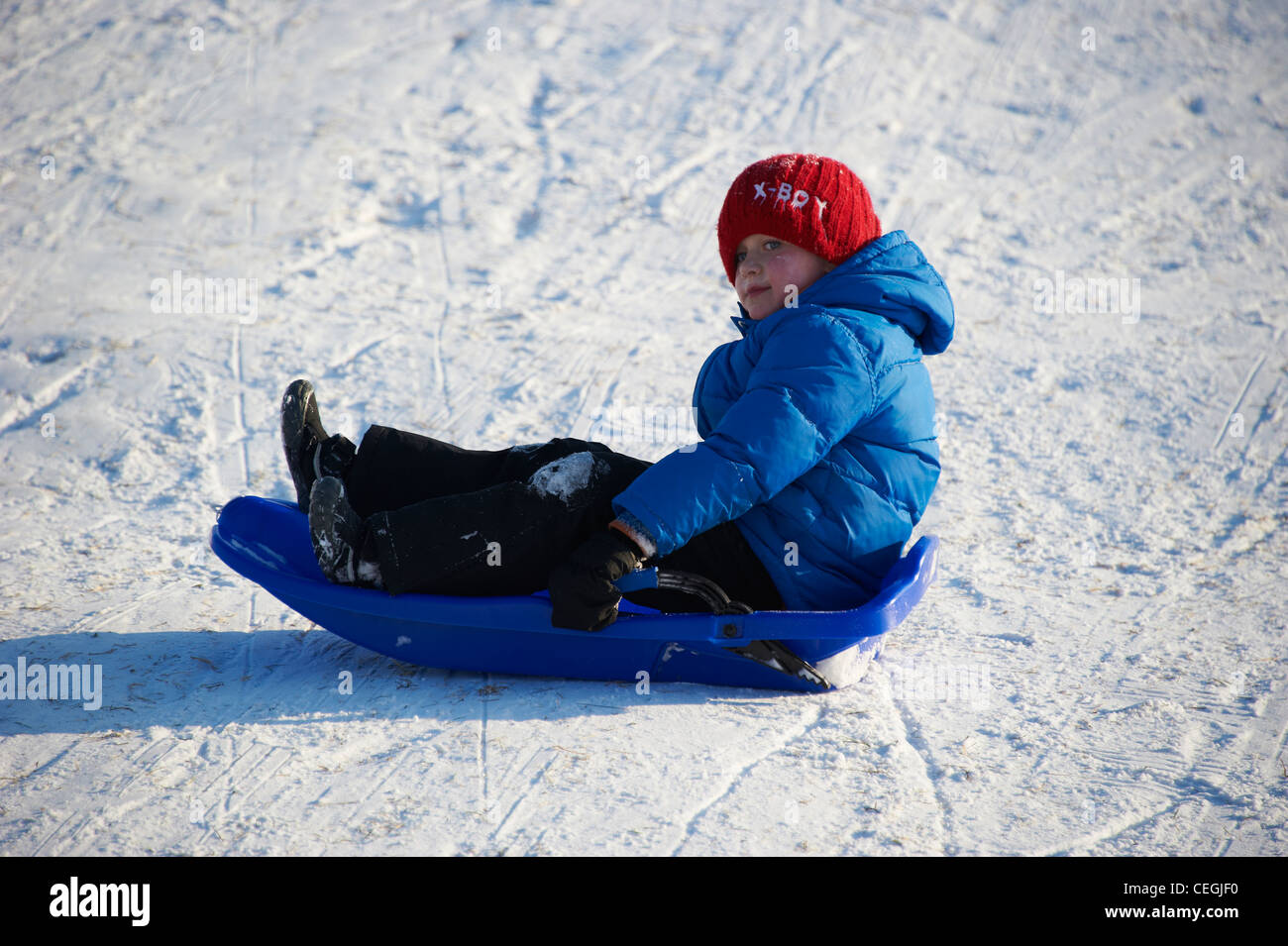 A child little boy sledding downhill winter Stock Photo - Alamy