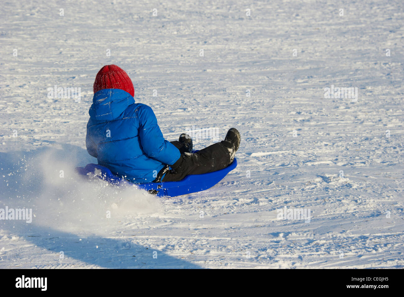 A child little boy sledding downhill winter Stock Photo - Alamy