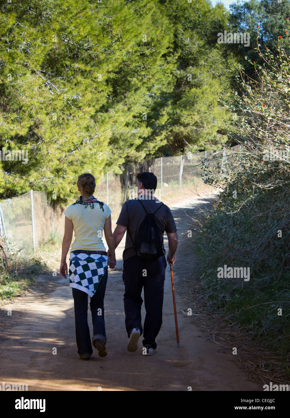 Couple walking along country lane Stock Photo - Alamy
