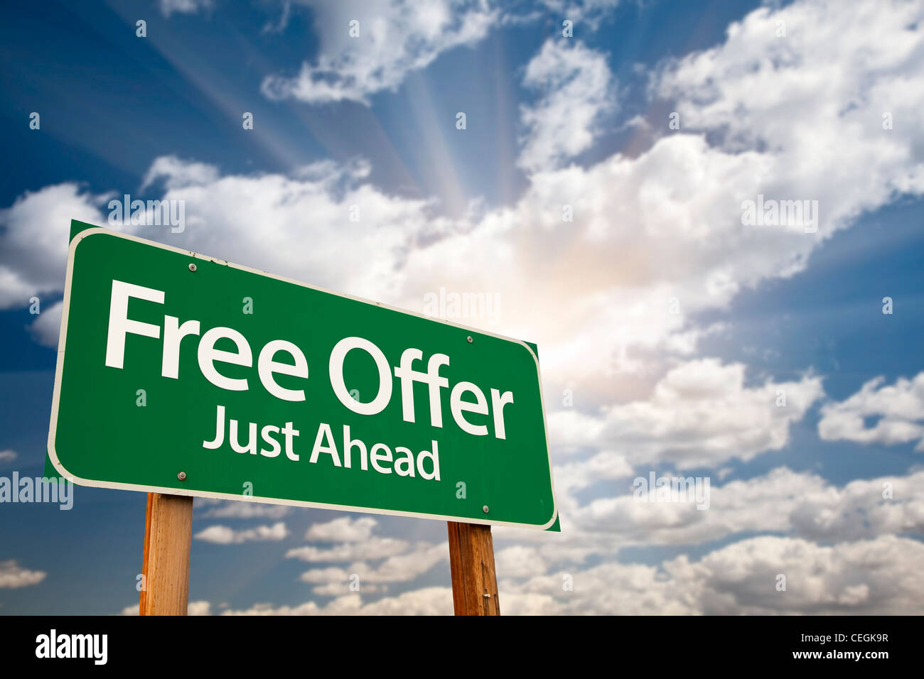 Free Offer Just Ahead Green Road Sign with Dramatic Clouds, Sun Rays ...
