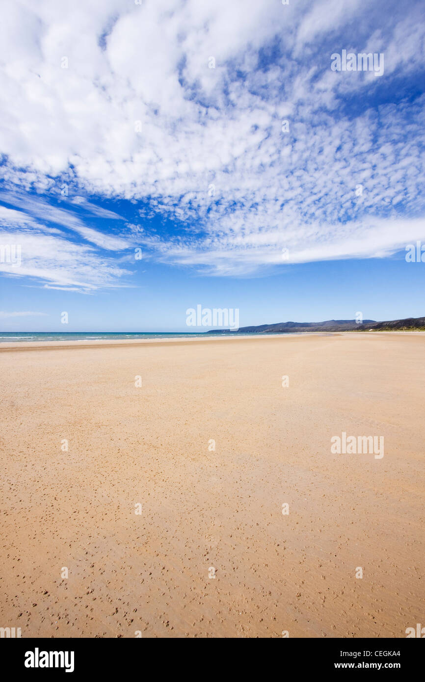 Wide sandy beach with blue sky and white clouds Stock Photo - Alamy