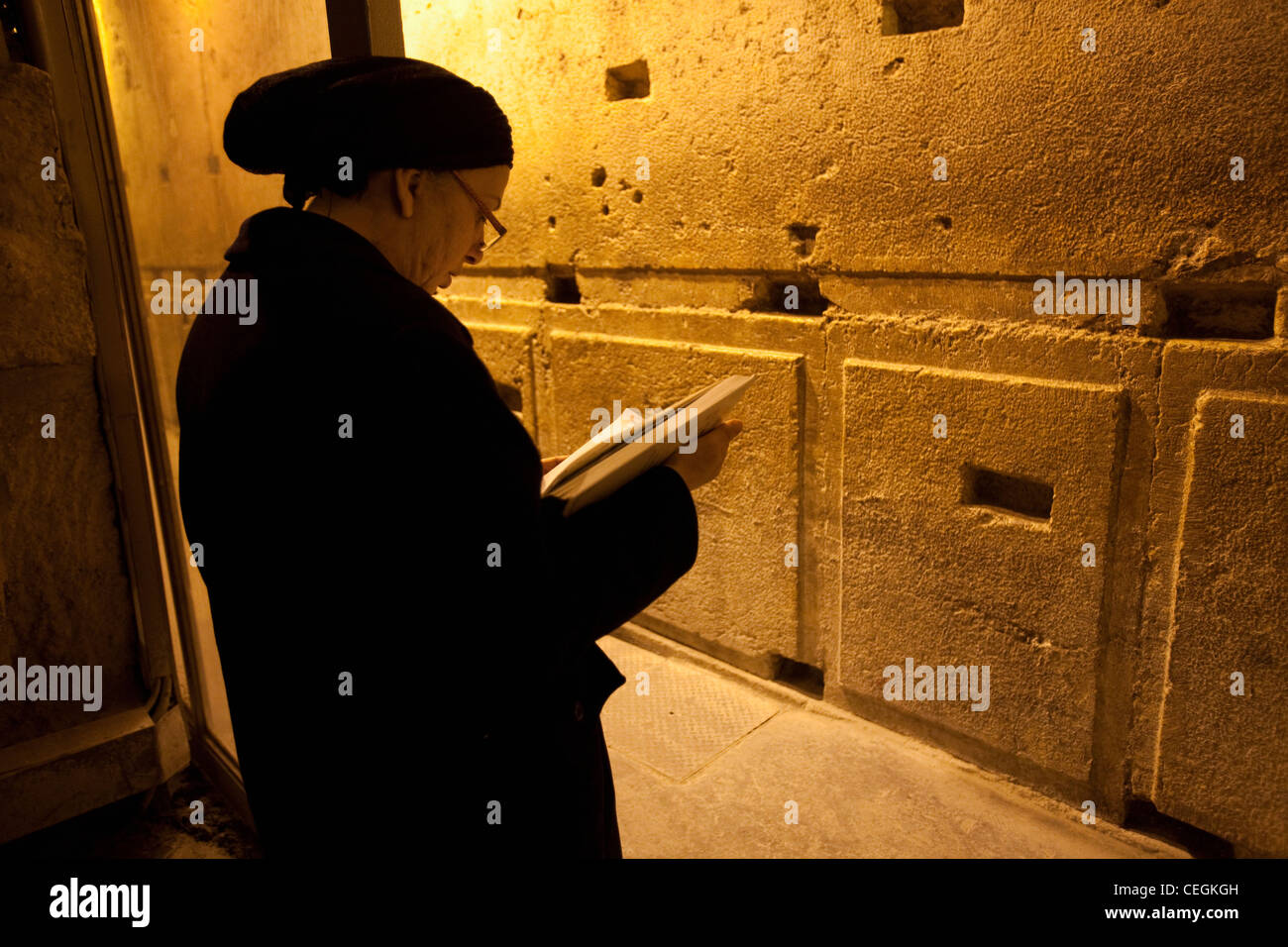 A religious Jewish woman praying in front of huge boulders from the ...