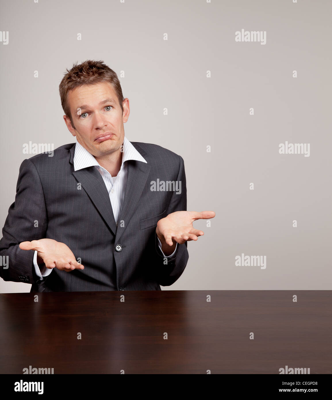 A confused business man holding his hands up in the air Stock Photo - Alamy