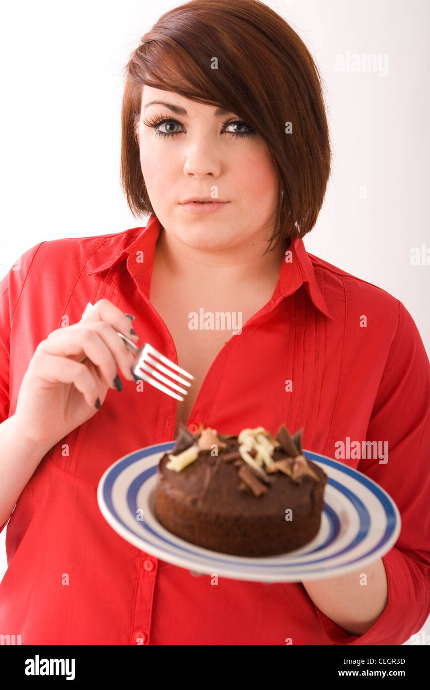 Slightly overweight woman wearing red blouse standing holding a large ...