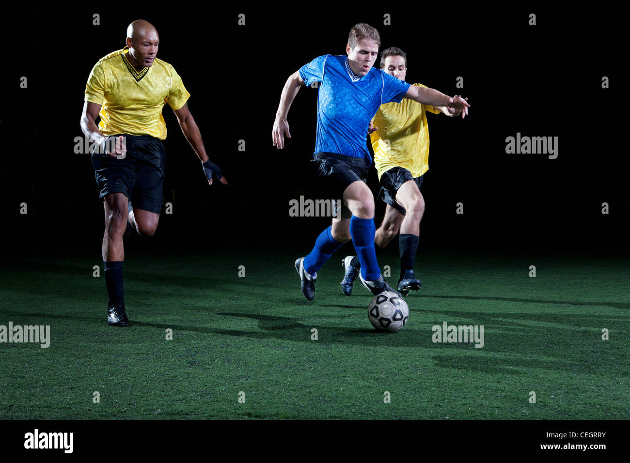 Soccer players tackling on pitch Stock Photo - Alamy