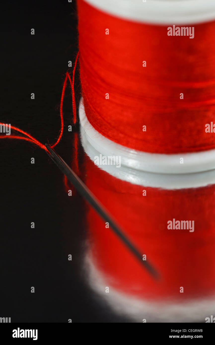 cotton reel and needle with reflections Stock Photo - Alamy