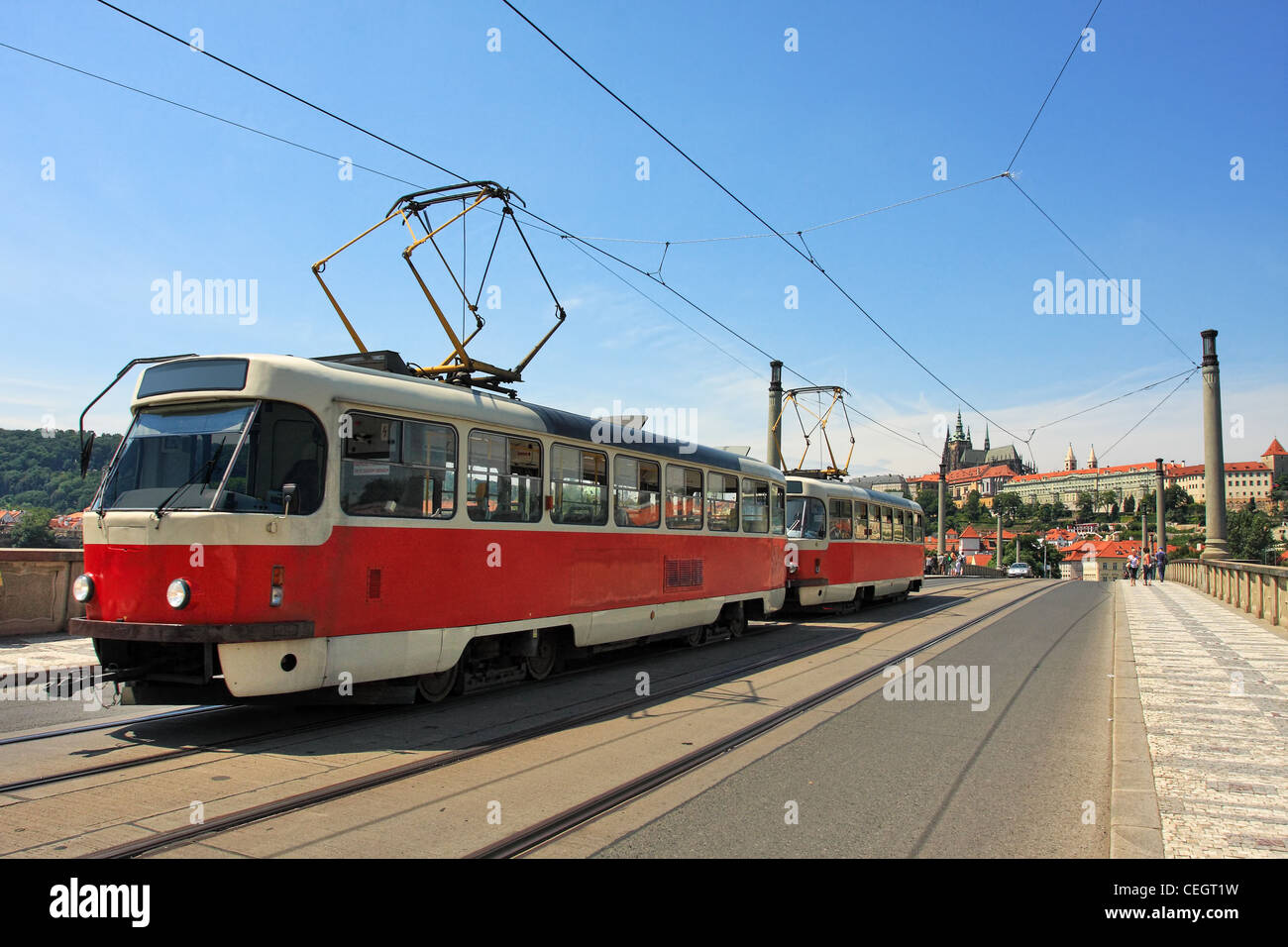 Red tram passing on Manes Bridge (Manesuv Most) and famous Prague ...