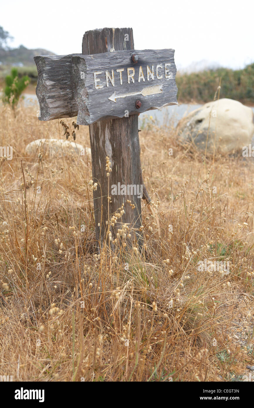 Wooden entrance sign in grass Stock Photo - Alamy
