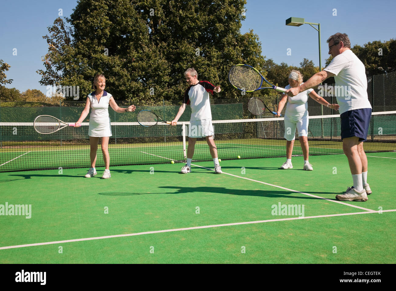 Senior and mature adults practising on tennis courts Stock Photo - Alamy