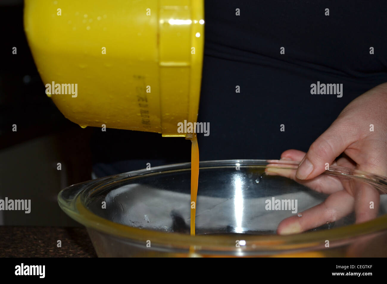 Pouring egg into mixing bowl Stock Photo - Alamy