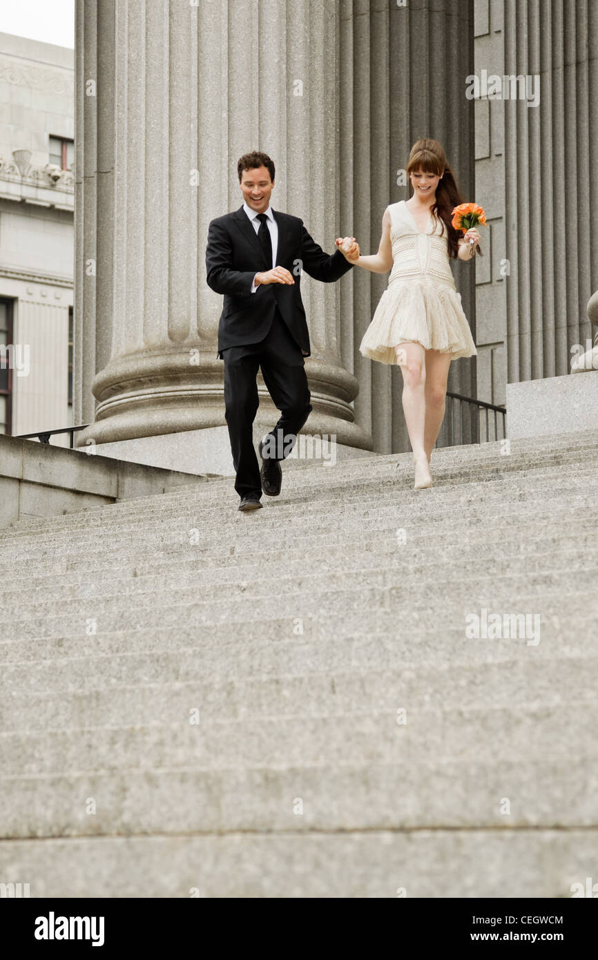 Newlywed couple descending steps together Stock Photo - Alamy
