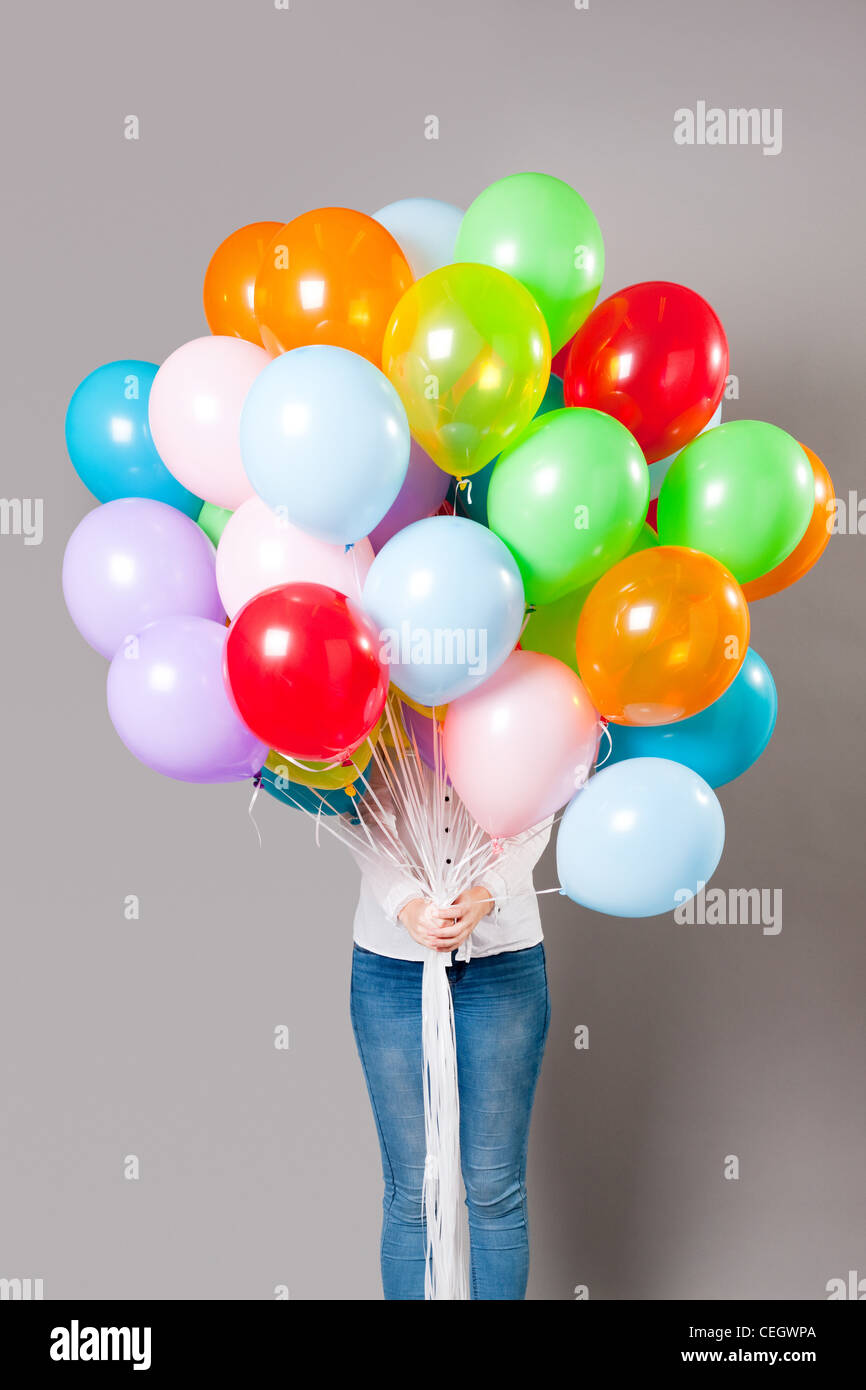 Woman holding large amount of balloons Stock Photo - Alamy