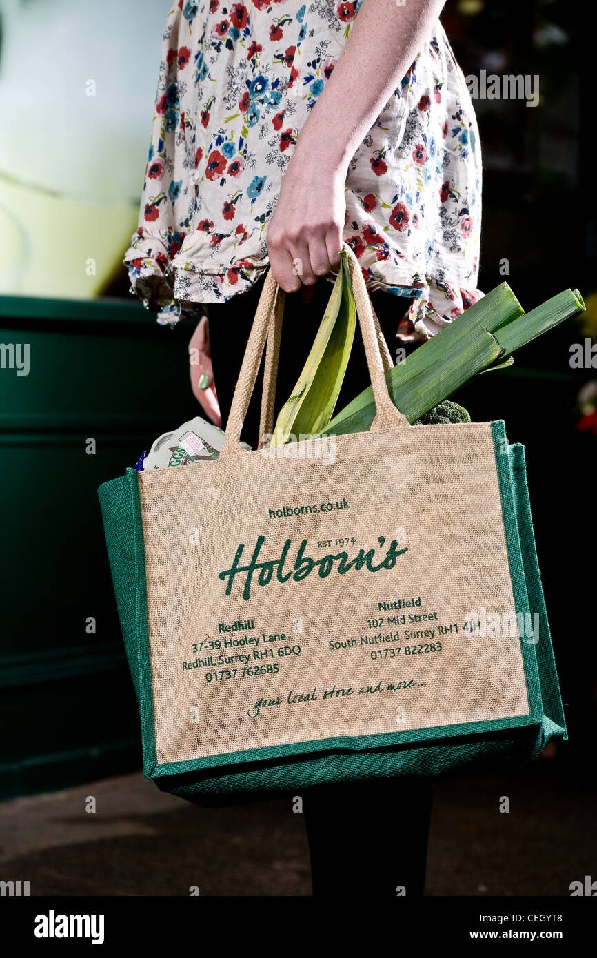Image of a shopper leaving a local convenience store with a the shops ...