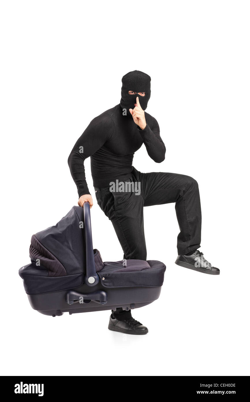 A man in robbery mask holding a carrycot with finger on the lips ...