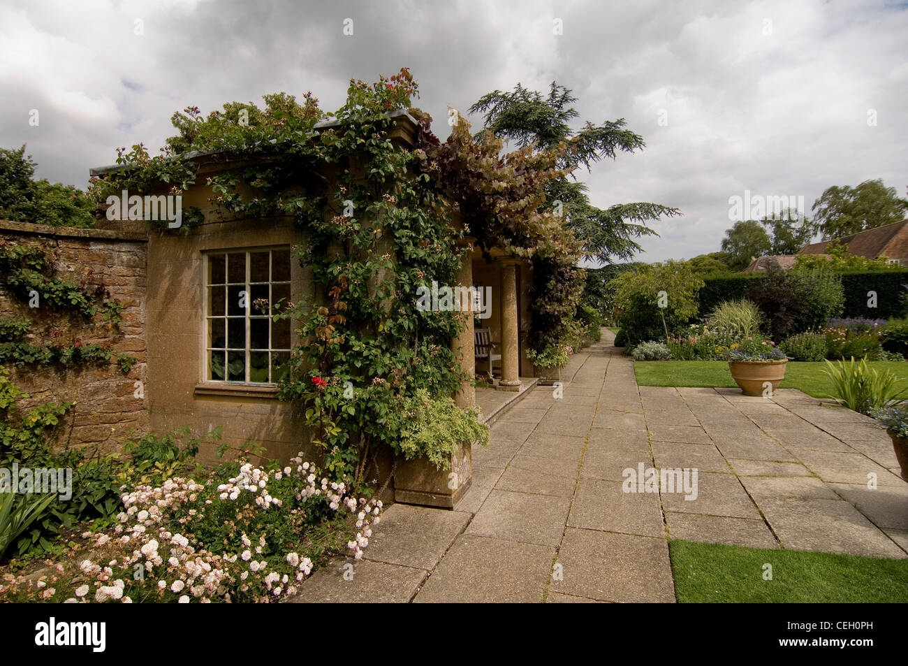 Stone Summer House with flowering roses trailing its sides Stock Photo ...