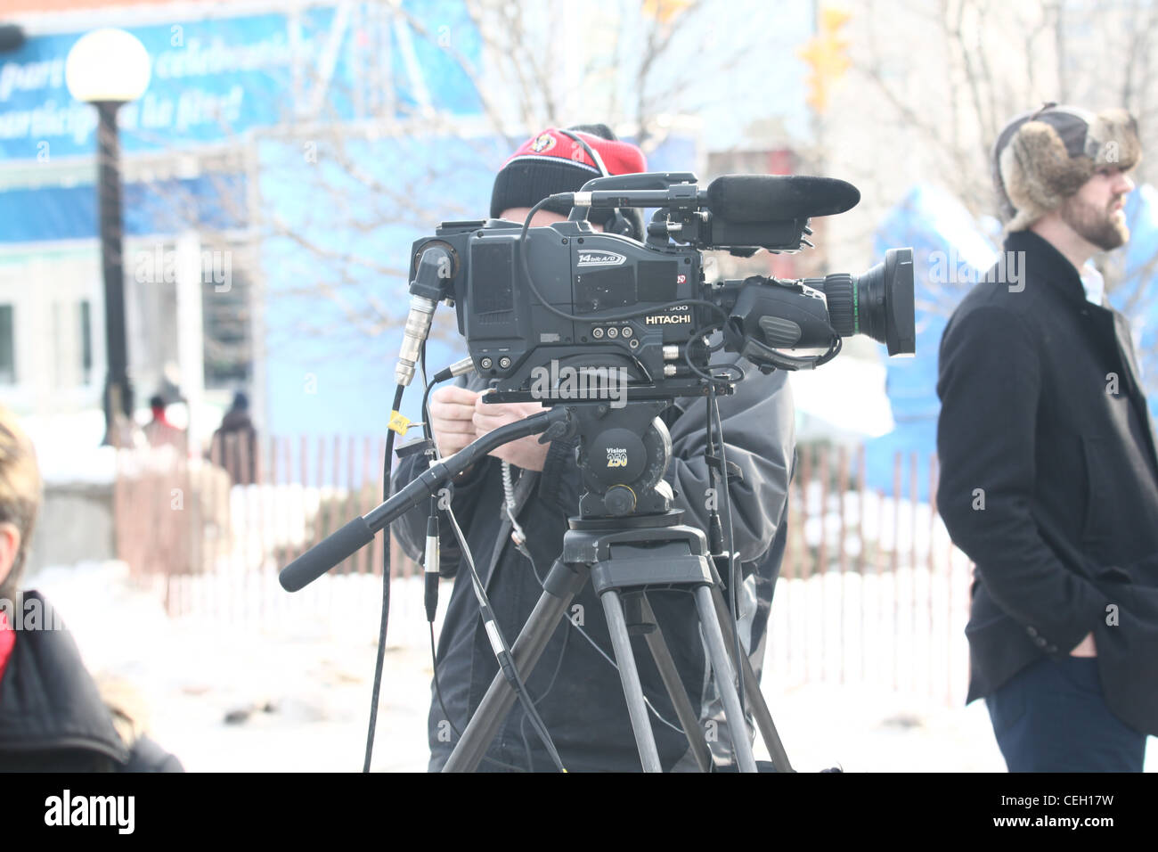 Profile of media camera with people in background Stock Photo - Alamy
