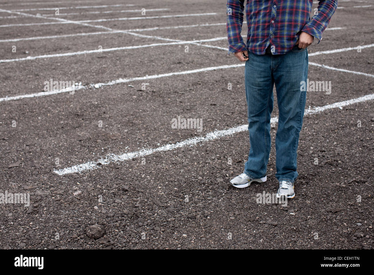 Anonymous man standing in empty parking lot Stock Photo - Alamy