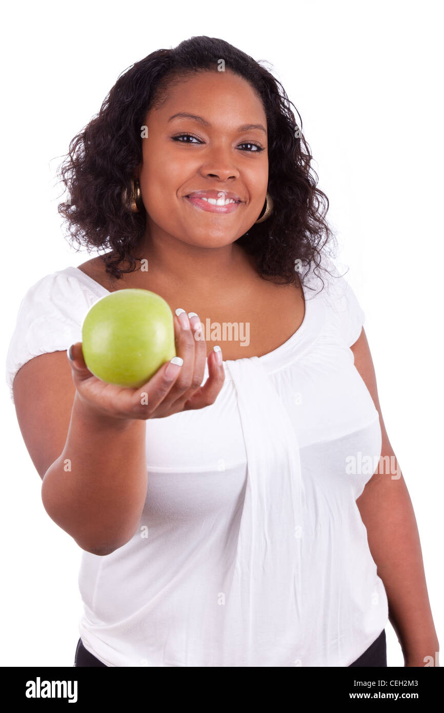 Young african american woman giving an green apple, isolated on white ...