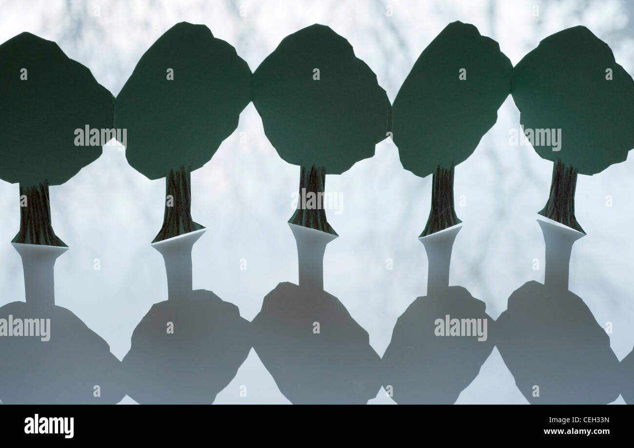 Line of cutout cardboard trees and reflection Stock Photo - Alamy