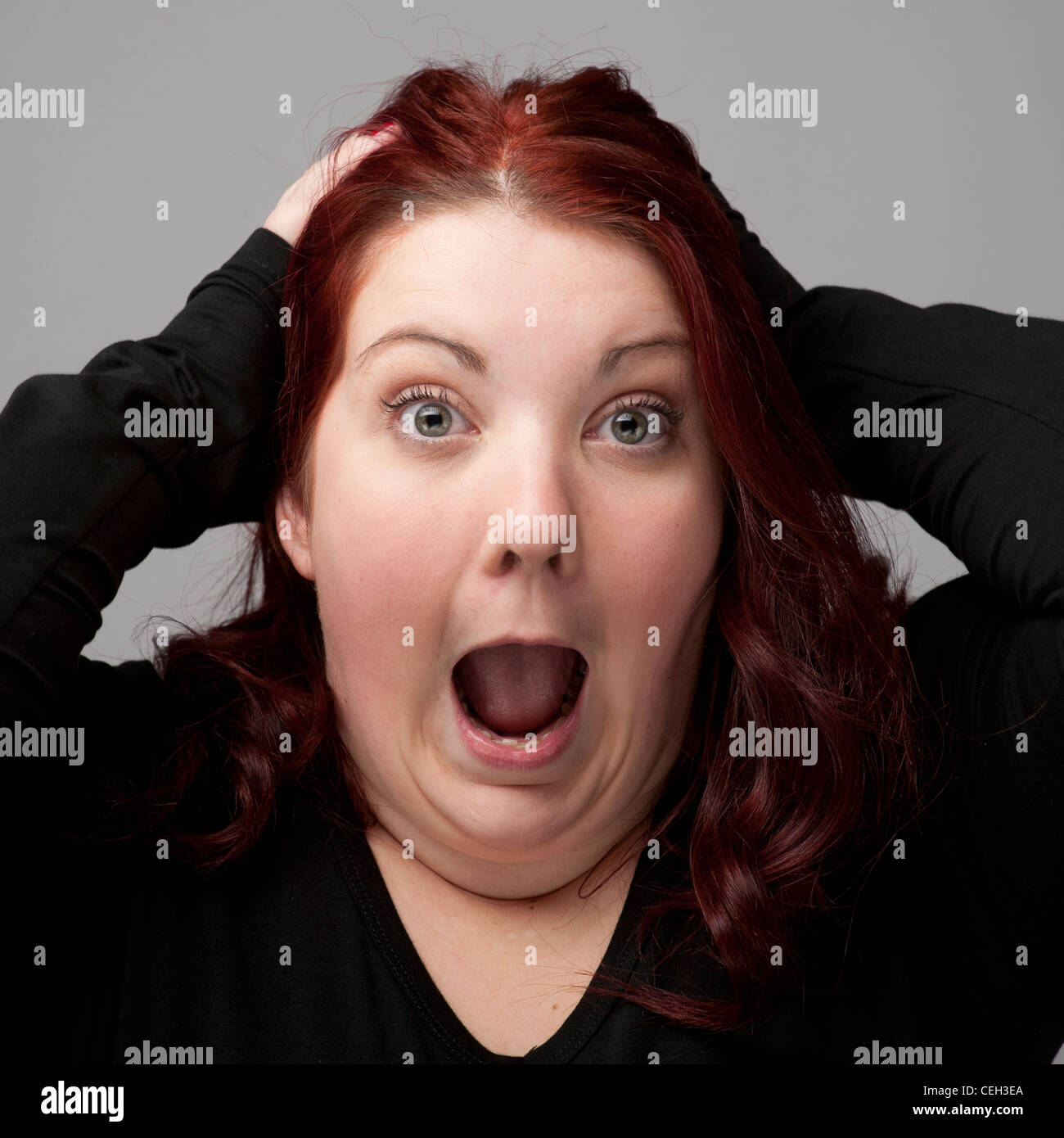 A auburn haired caucasian woman looking worried shocked concerned ...