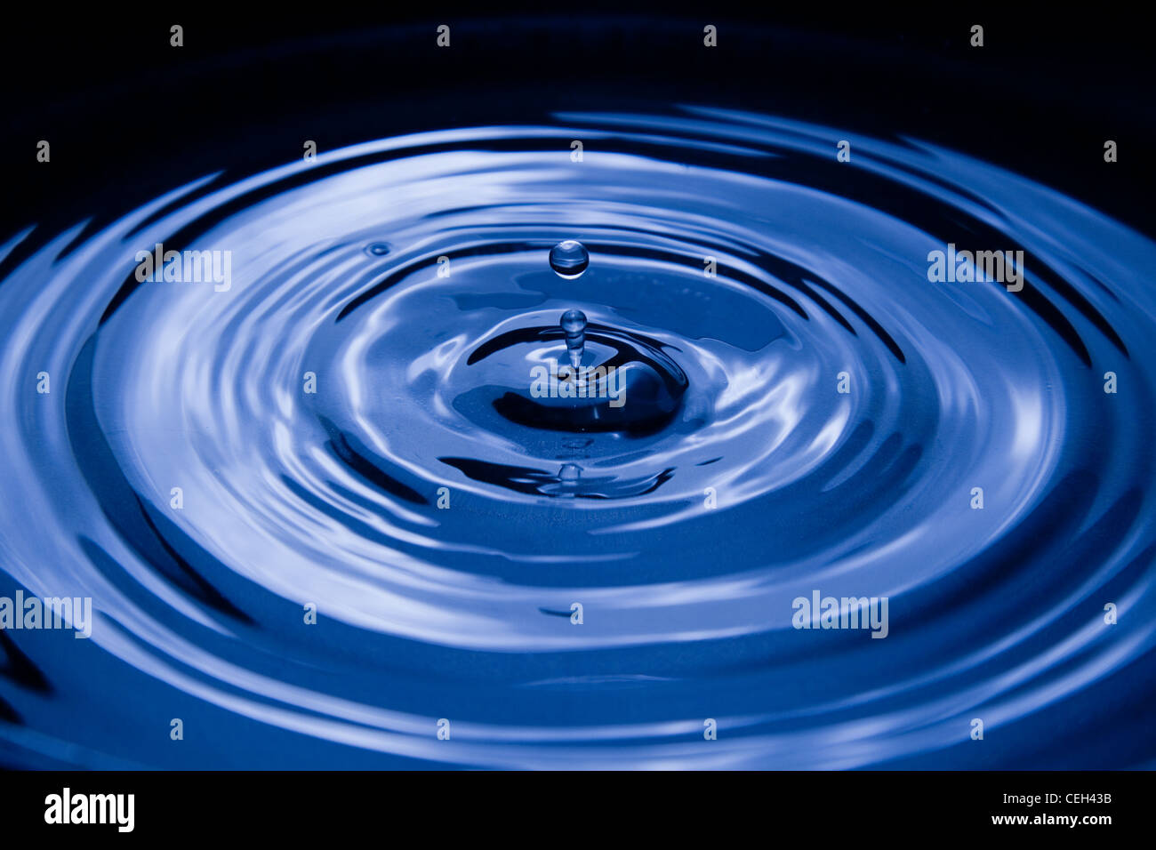 Water drop making a ripple on the surface Stock Photo - Alamy