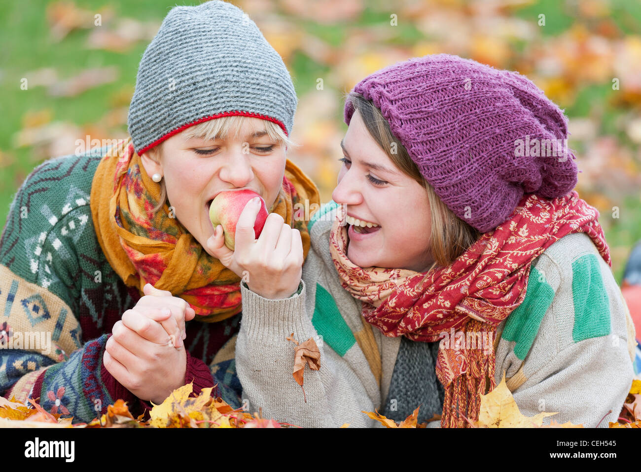 Two girls sharing an apple Stock Photo - Alamy