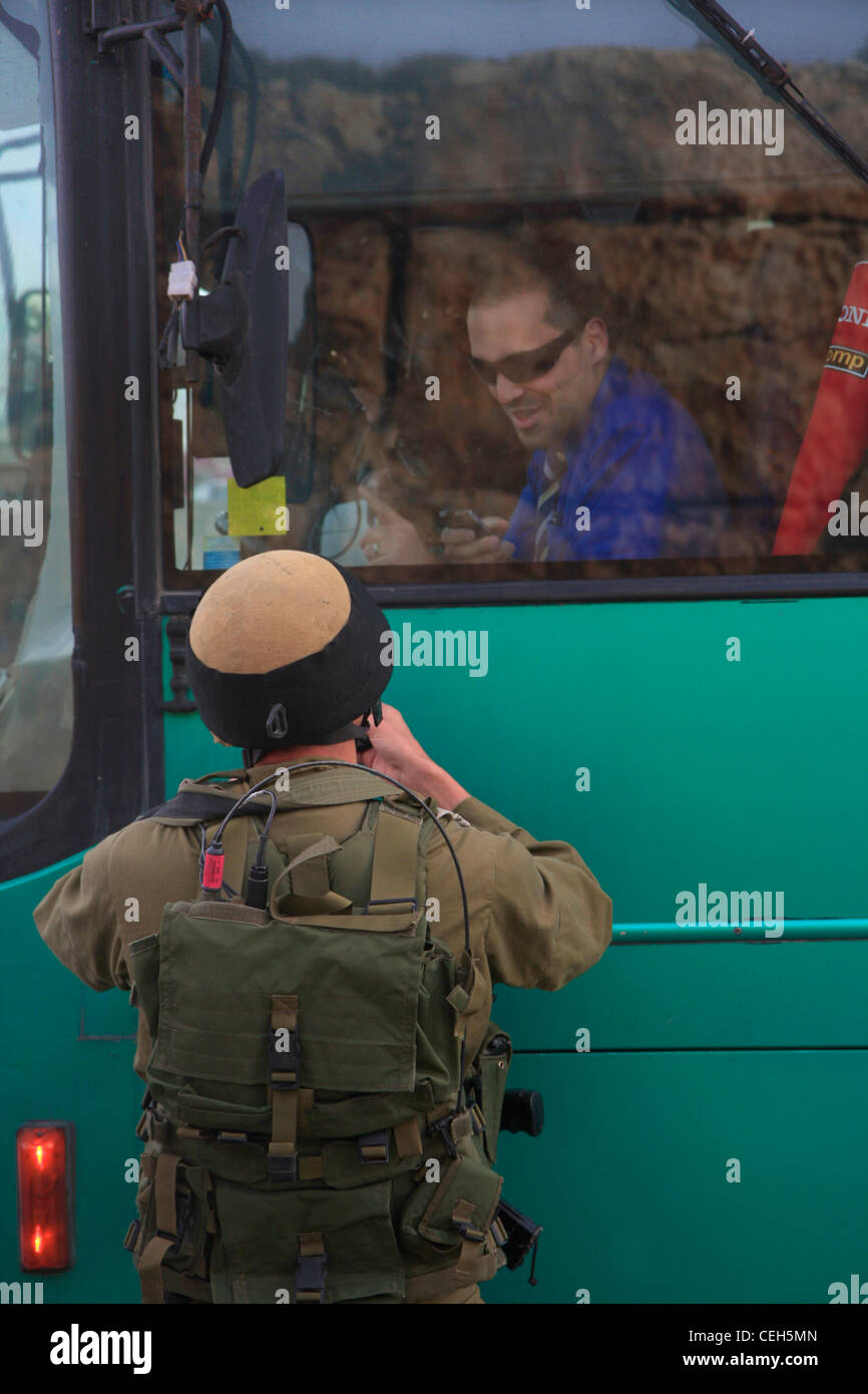 An Israeli soldier uses a cell phone to communicate through a window ...