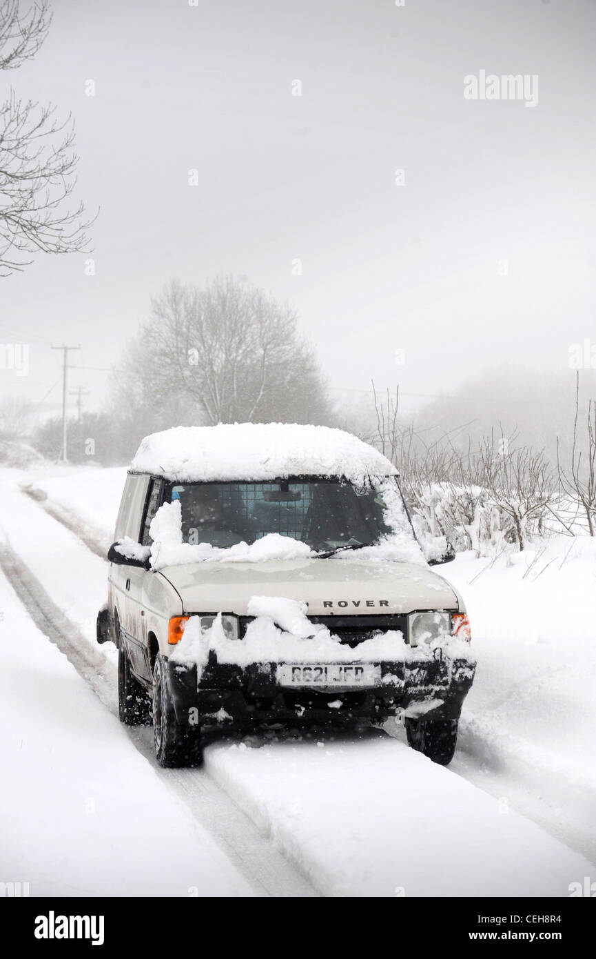 A Land Rover 4x4 on a lane in snowy conditions in Gloucestershire UK ...