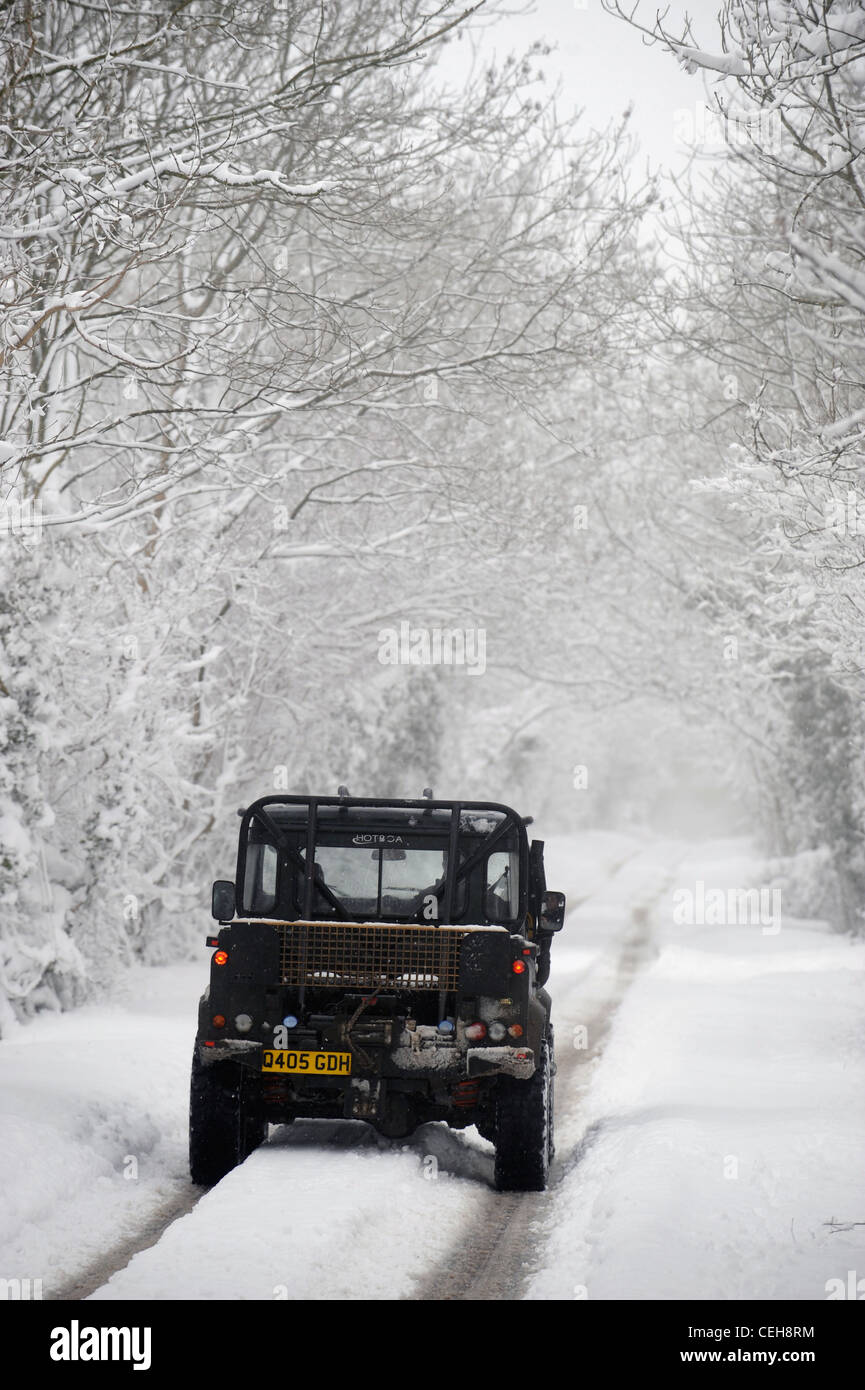 A Land Rover jeep 4x4 on a lane in snowy conditions in Gloucestershire ...