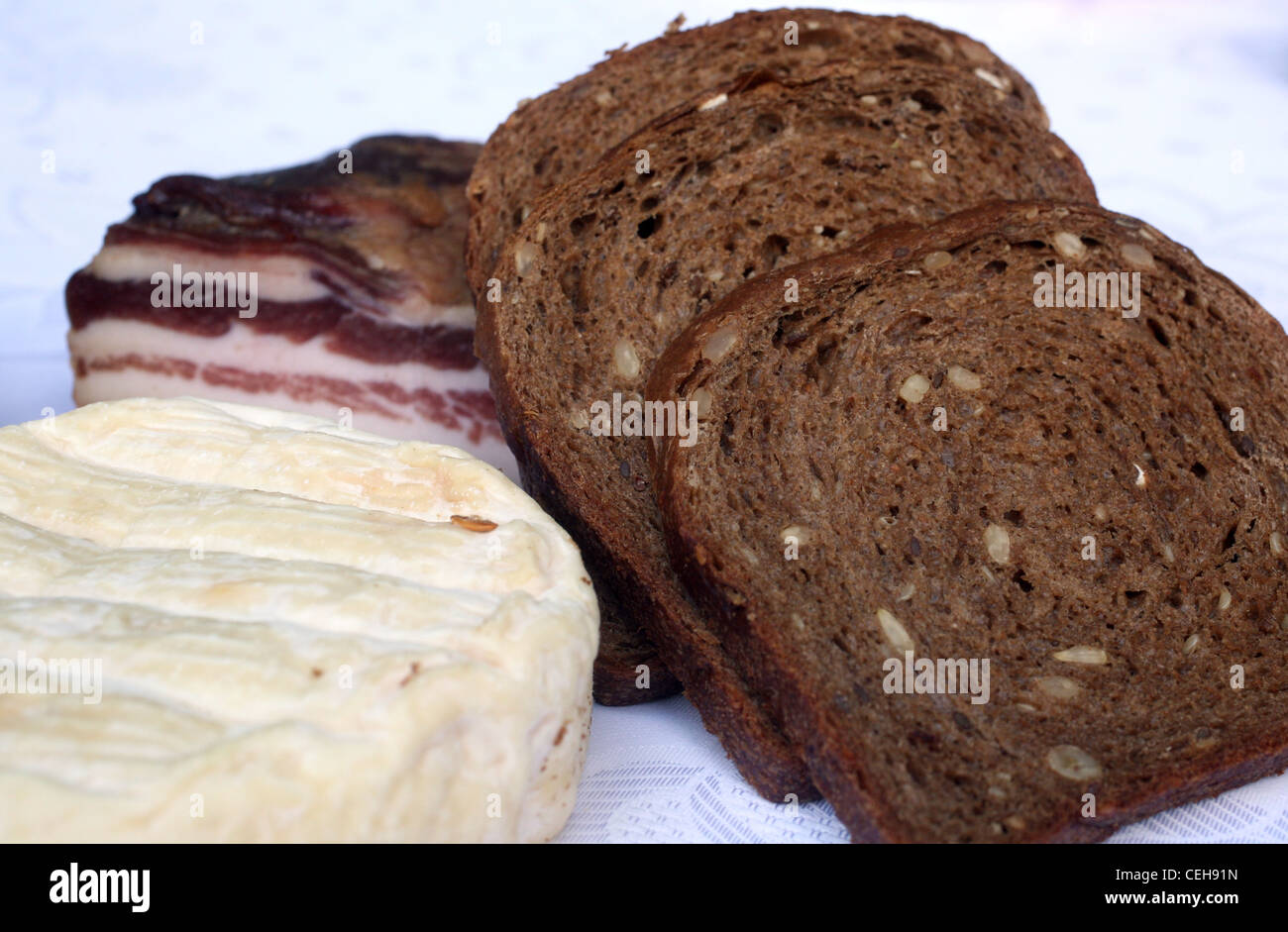 Rustic still life of bread, cheese and bacon Stock Photo - Alamy