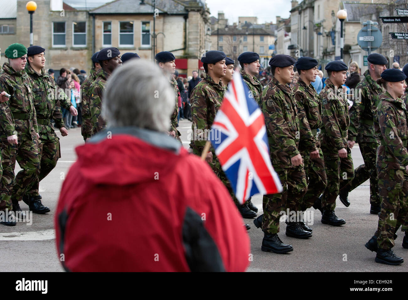 A woman holding a Union Jack flag watches as members of the 9th ...