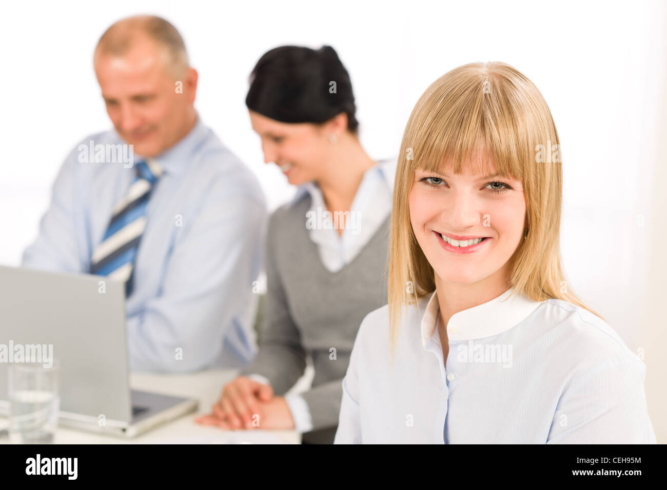 Businesswoman smiling at team meeting with colleagues Stock Photo - Alamy