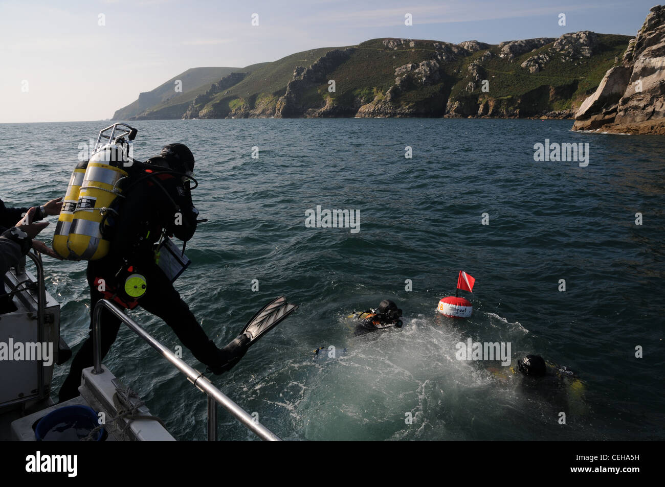Divers entering the water to dive on the east coast of Lundy, North ...