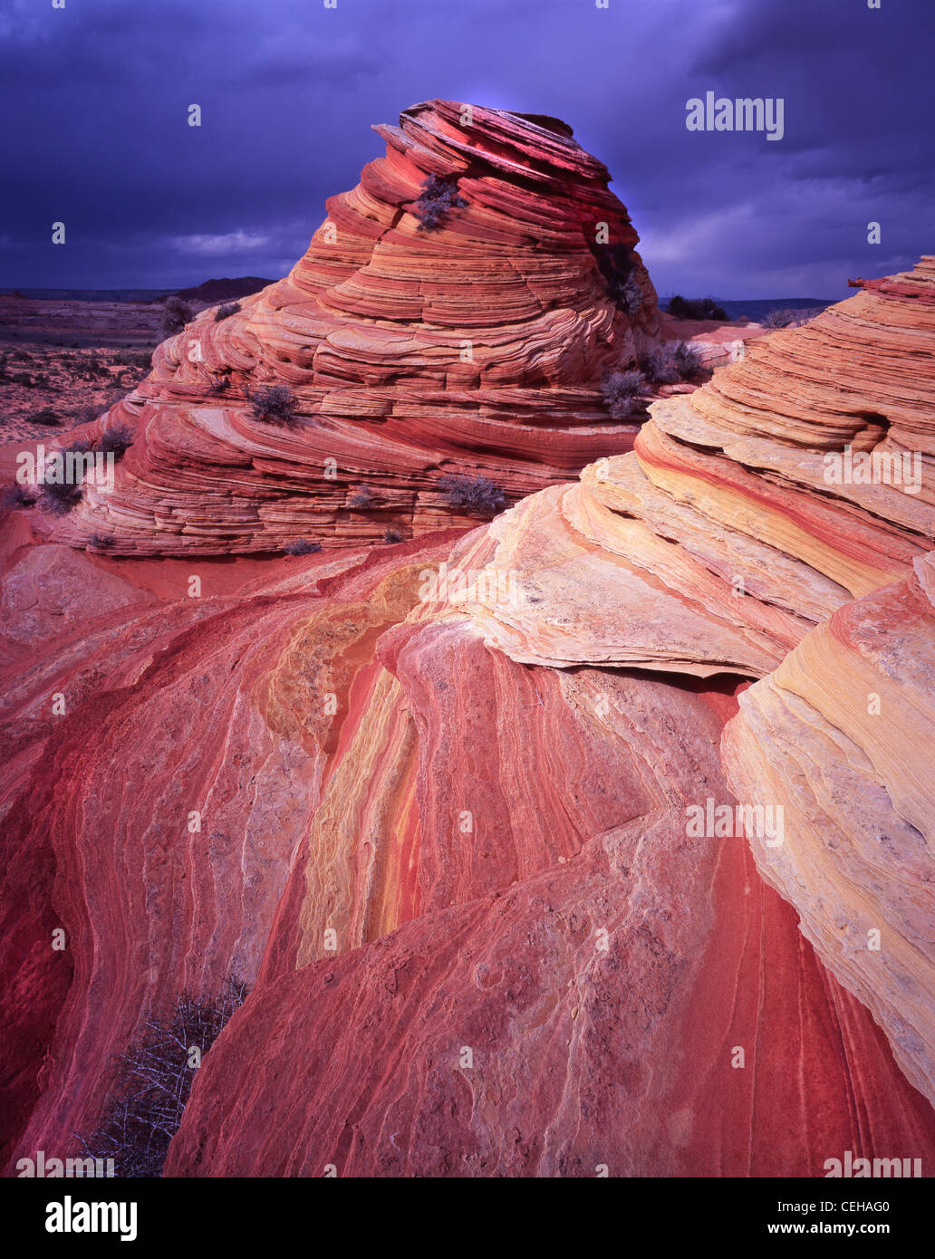 Colorful sandstone buttes light up against dark stormy clouds in Coyote ...