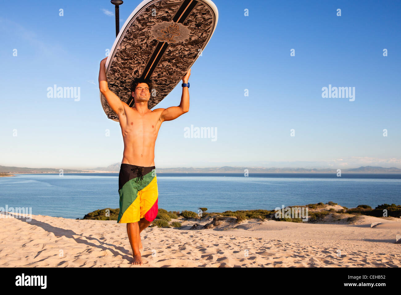 surfer carrying his board over his head Stock Photo - Alamy