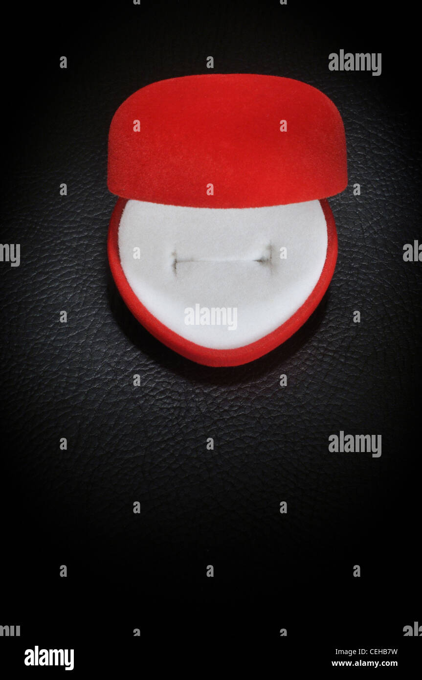 red velvet ring box on the black leather background Stock Photo - Alamy