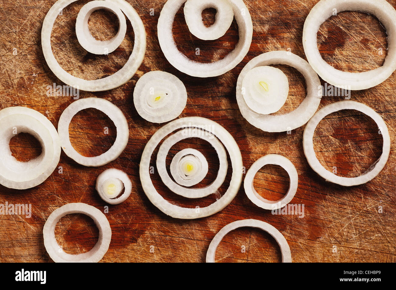 Onion rings on wooden cutting table Stock Photo - Alamy