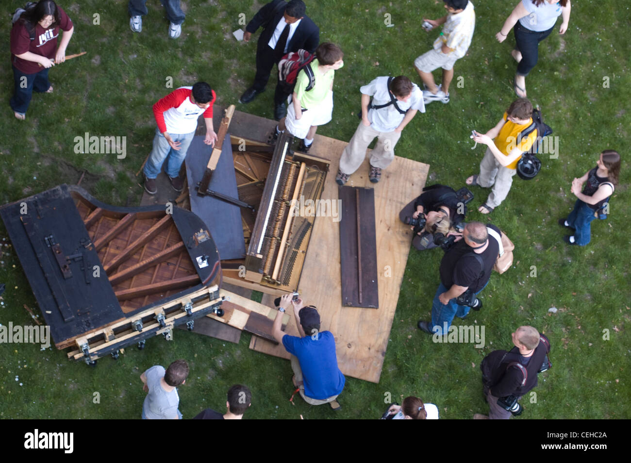 Onlookers and press examine the fallen grand piano and the upright ...