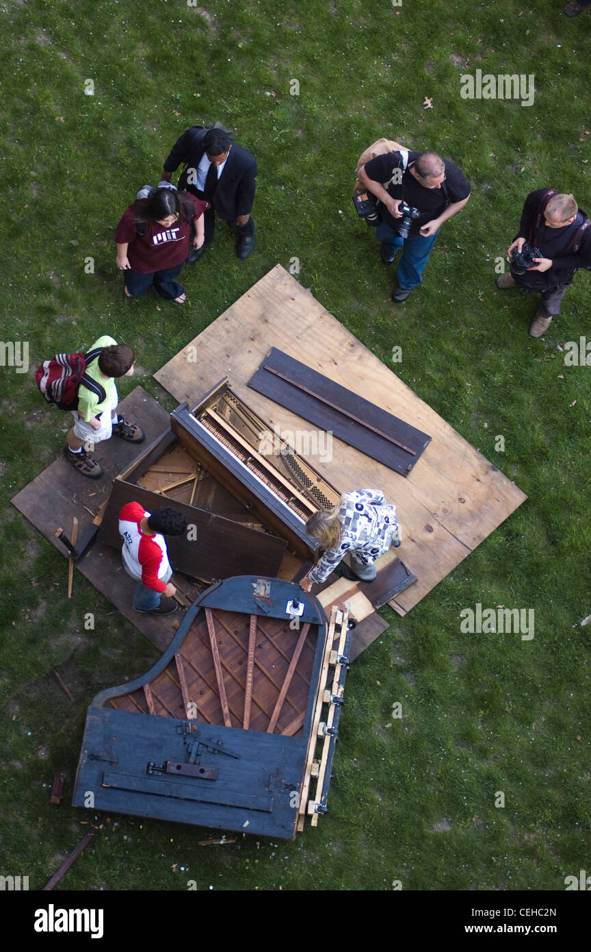 Onlookers and press examine the fallen grand piano and the upright ...