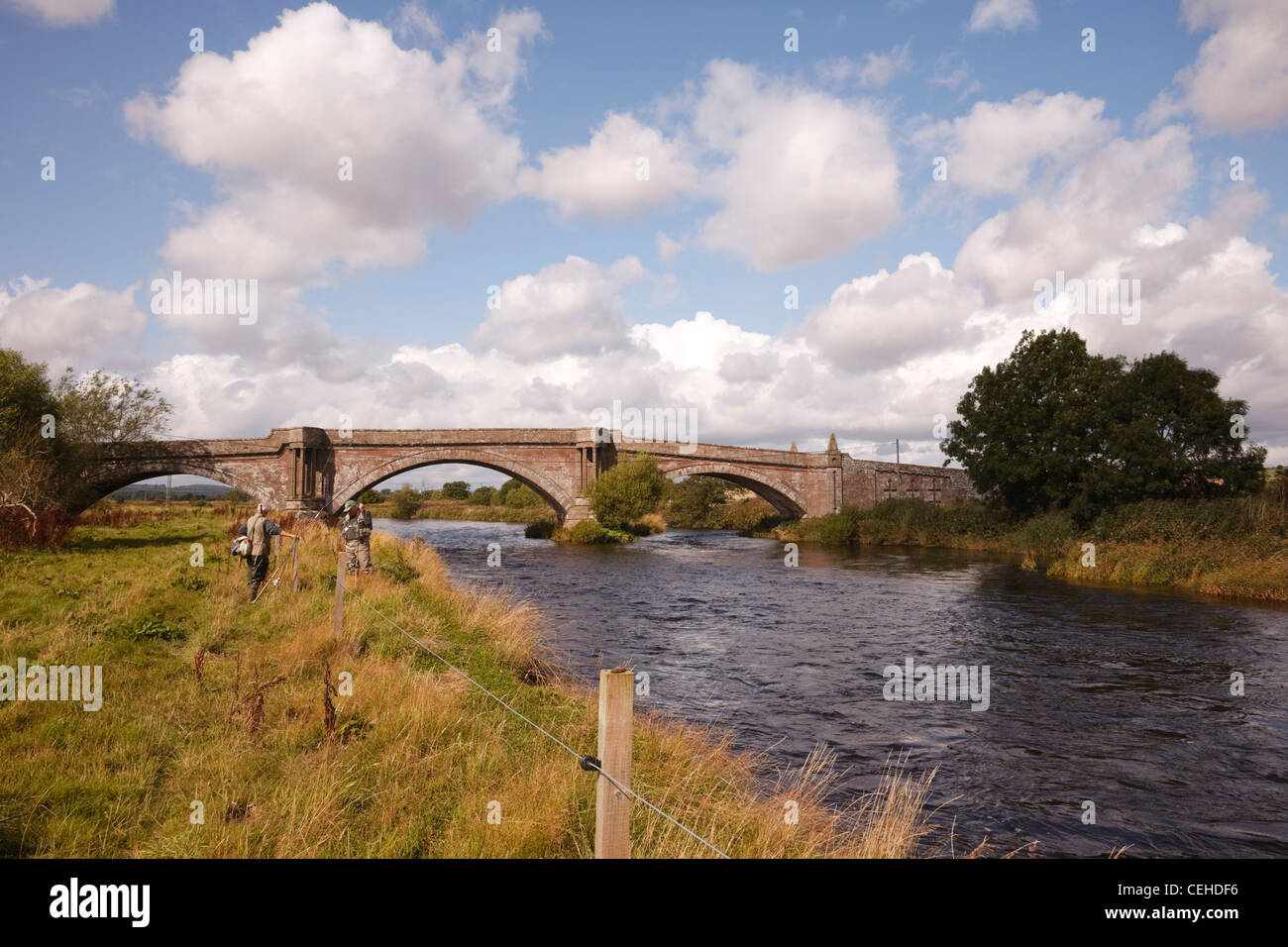 Two fishermen on the banks of the River South Esk at the Bridge of Dun, Montrose, Angus ...