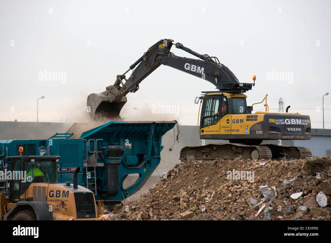 360 Digger working on a construction site filling a stone crusher Stock ...