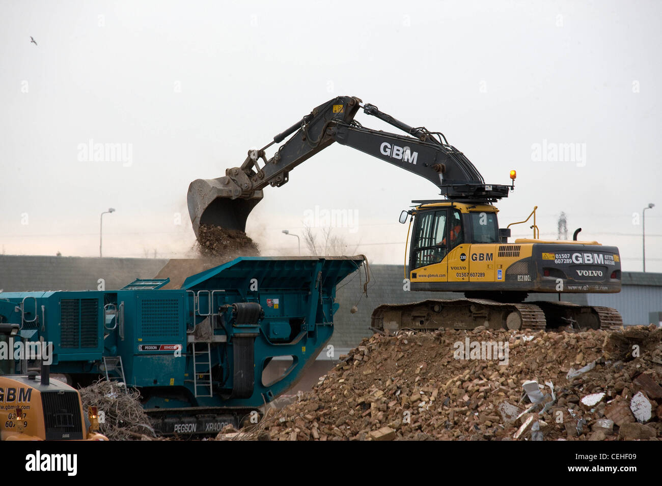 360 Digger working on a construction site filling a stone crusher Stock ...